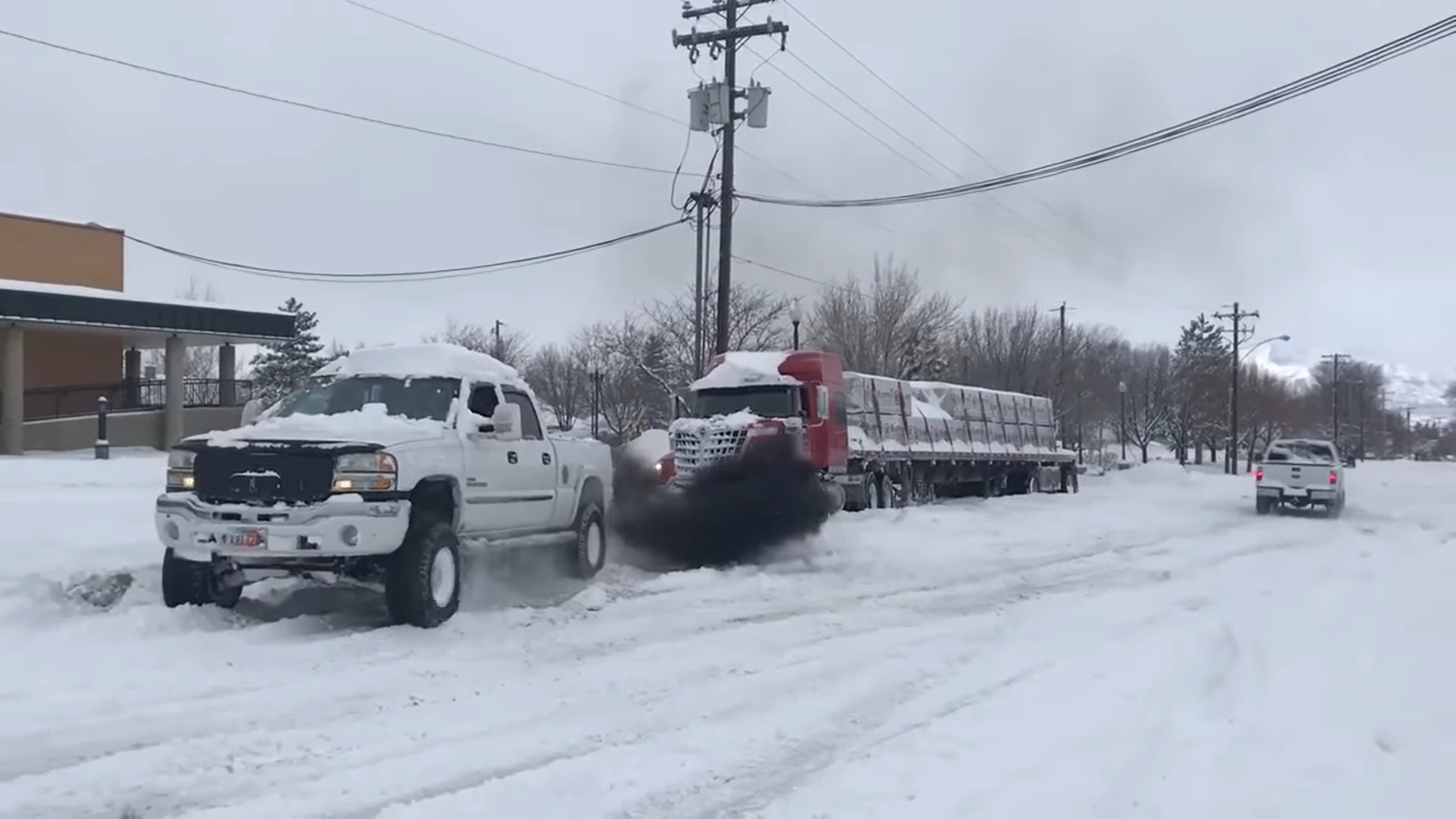VIDEO: Snowed-in flatbedder gets a tow from a surprisingly helpful pickup