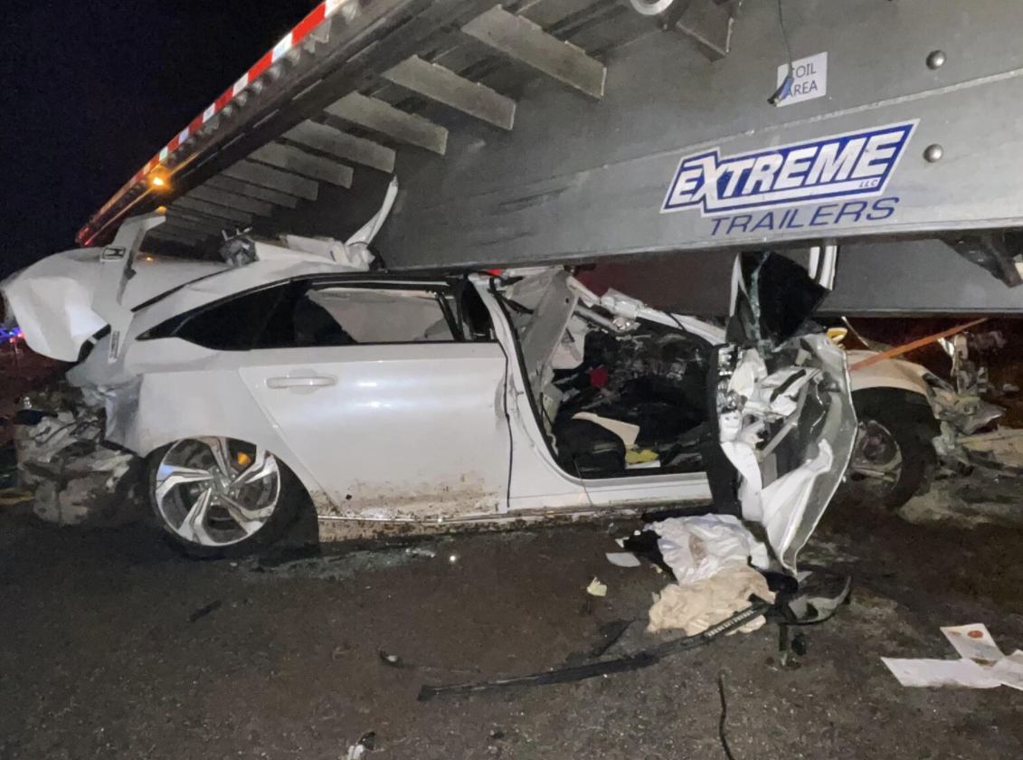 Car ends up beneath flatbed in two vehicle wreck