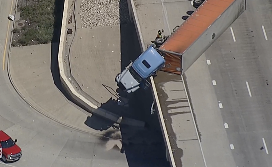 Driver found outside of truck hanging off overpass