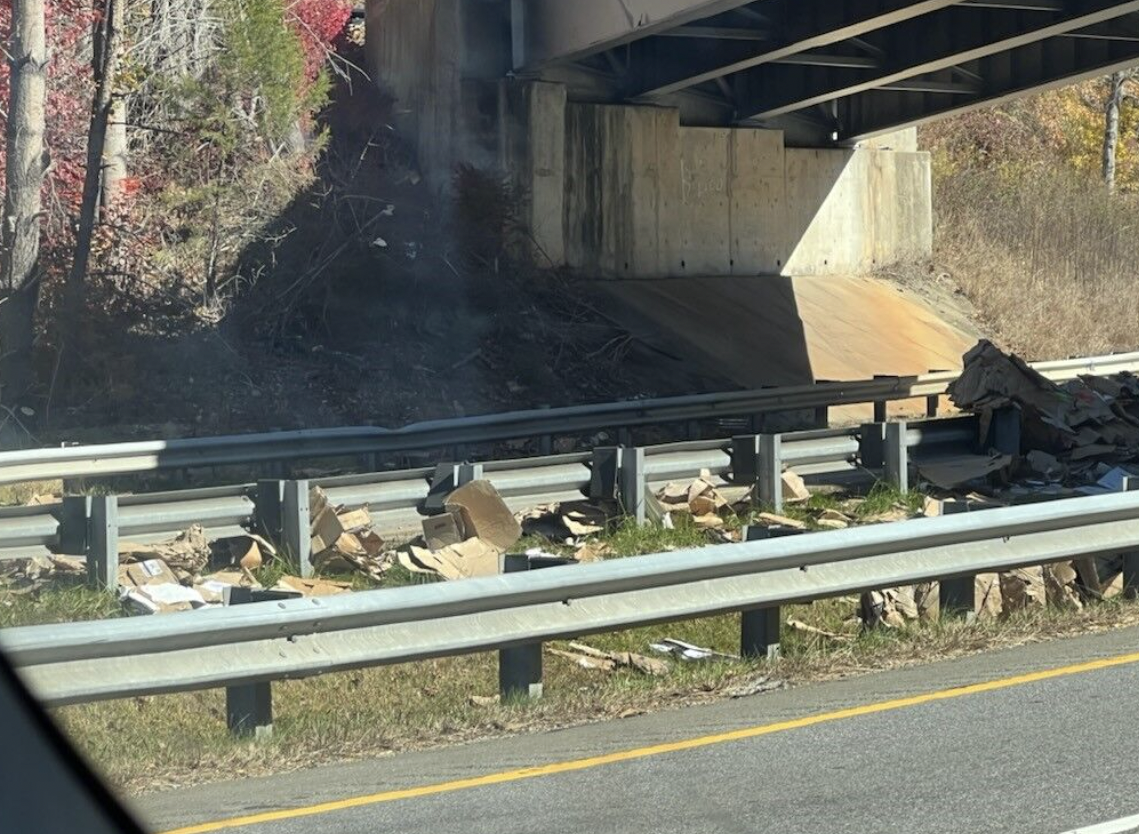 Tipped trailer empties load over side of overpass