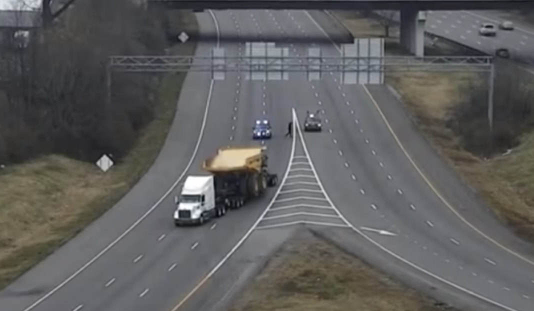 Trucker with oversize load avoids striking railroad bridge by reversing ...