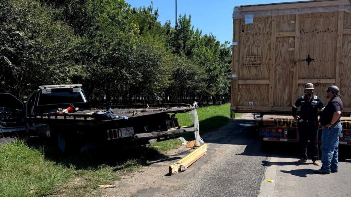 Passing oversize load knocks wrecker into tow truck driver assisting a ...