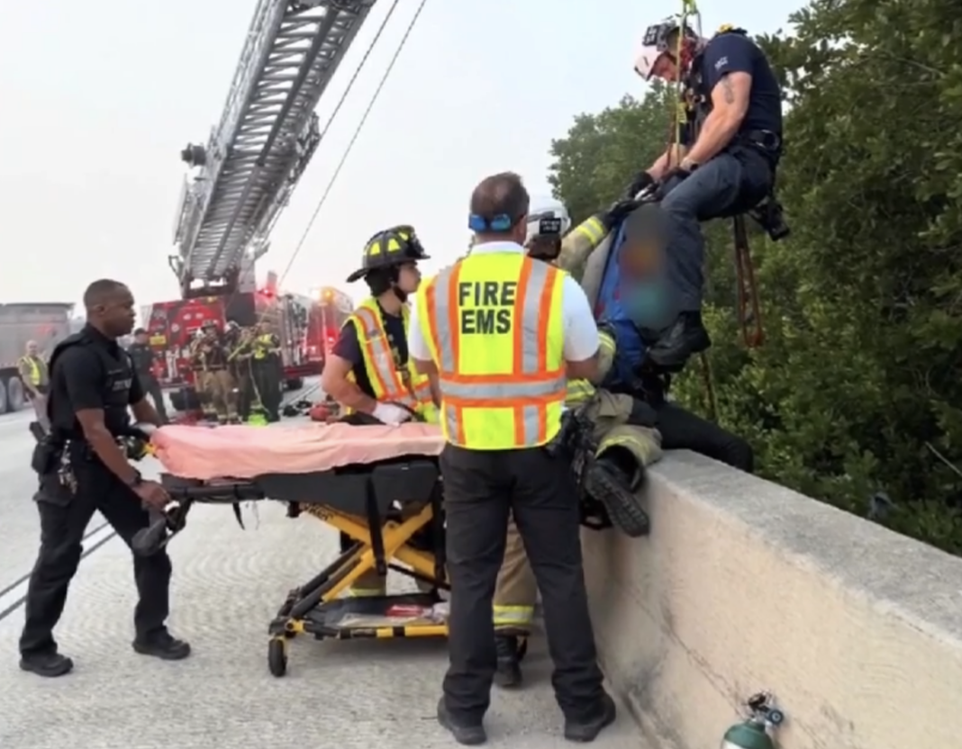 Motorist balancing on bridge wall after crash with semi truck rescued ...