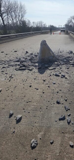 Excavator hauled by semi truck pops through bridge deck following ...